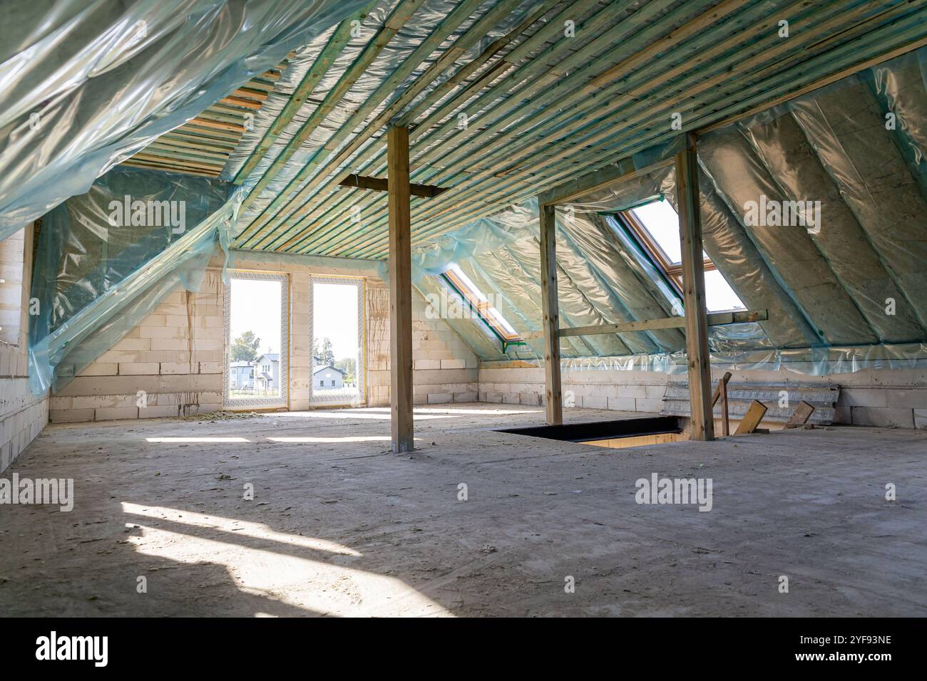 Spacious attic under construction with thermal insulation and skylights ...