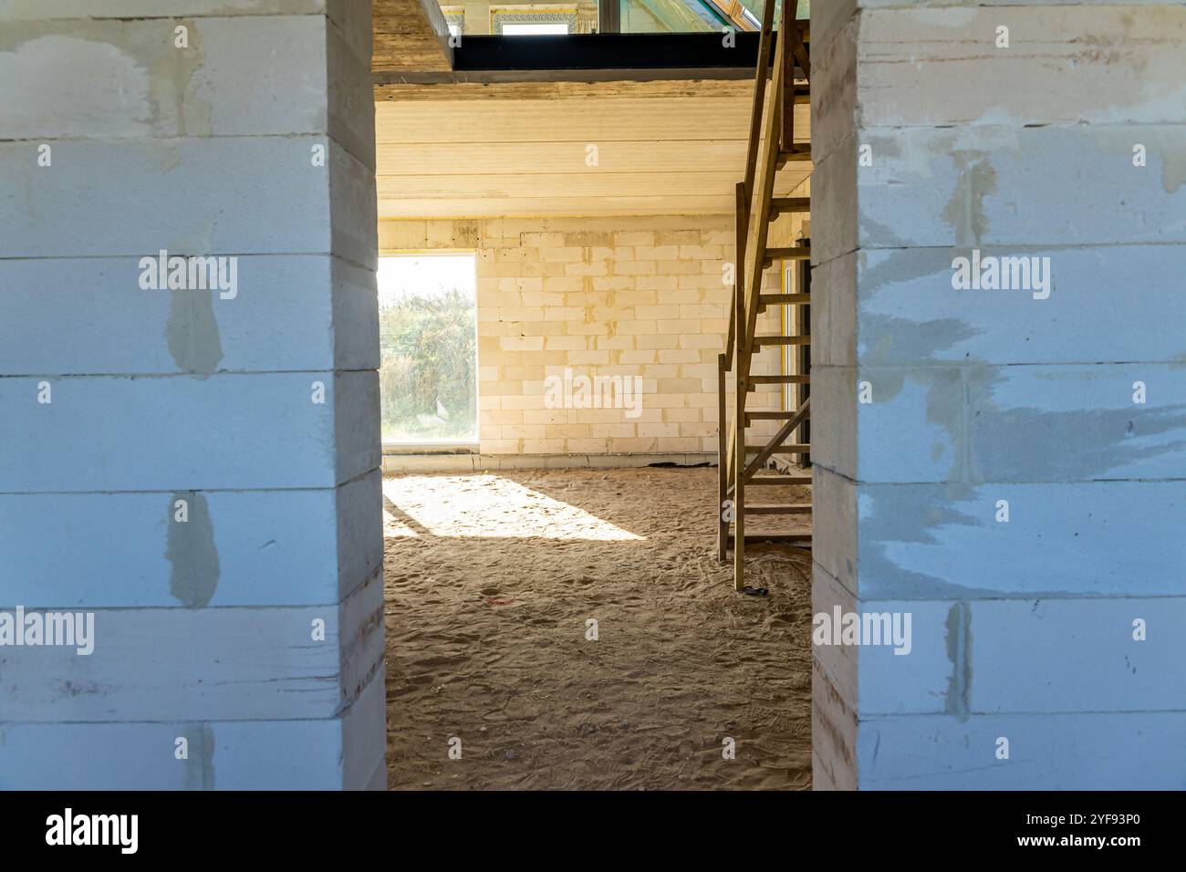 Sunlit corner of a room in an under-construction house with exposed ...