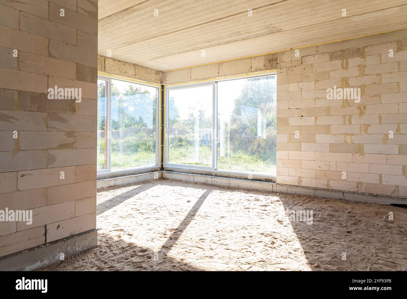 Sunlit corner of a room in an under-construction house with exposed ...