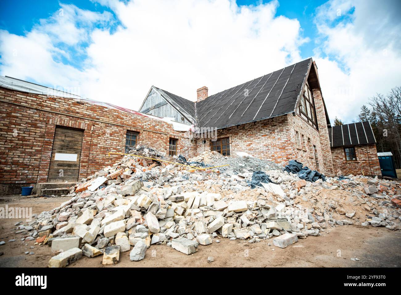 Rubble pile in front of a partially demolished brick building with a ...