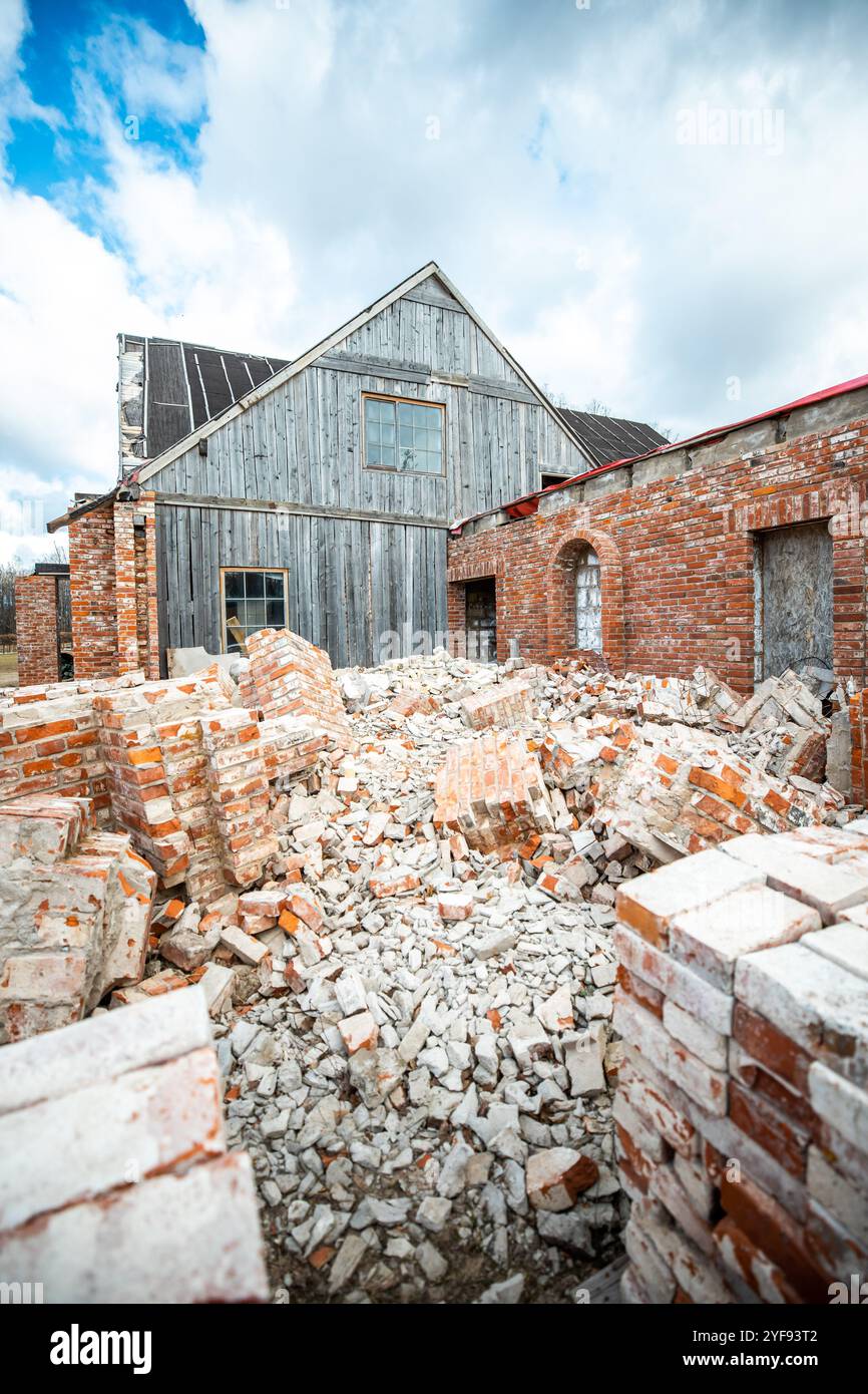 Rubble pile in front of a partially demolished brick building with a ...