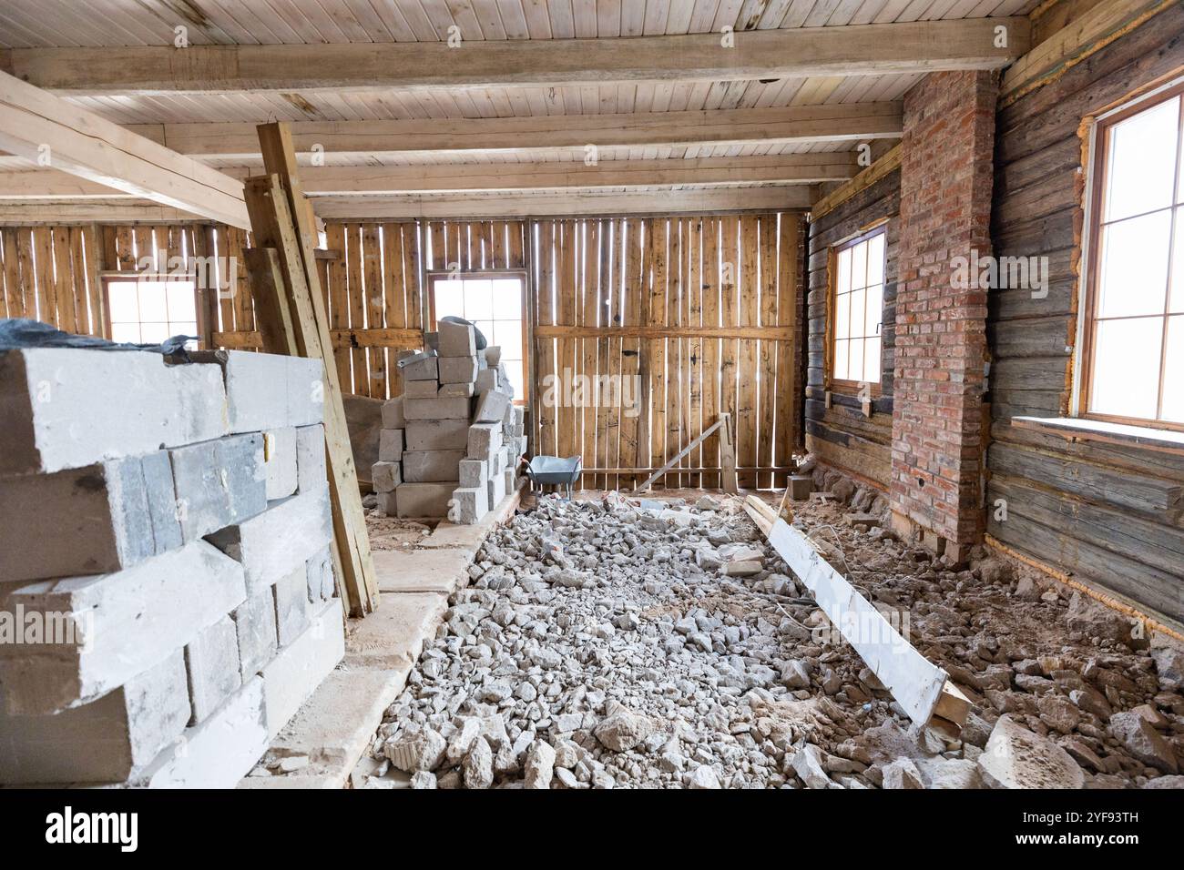 Interior renovation in progress with exposed wooden beams and pile of ...