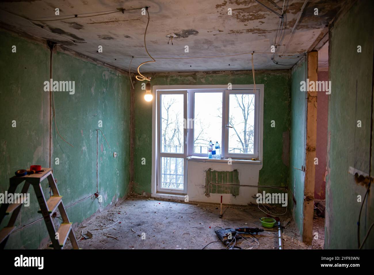 Abandoned building interior in disrepair with debris, exposed pipes ...