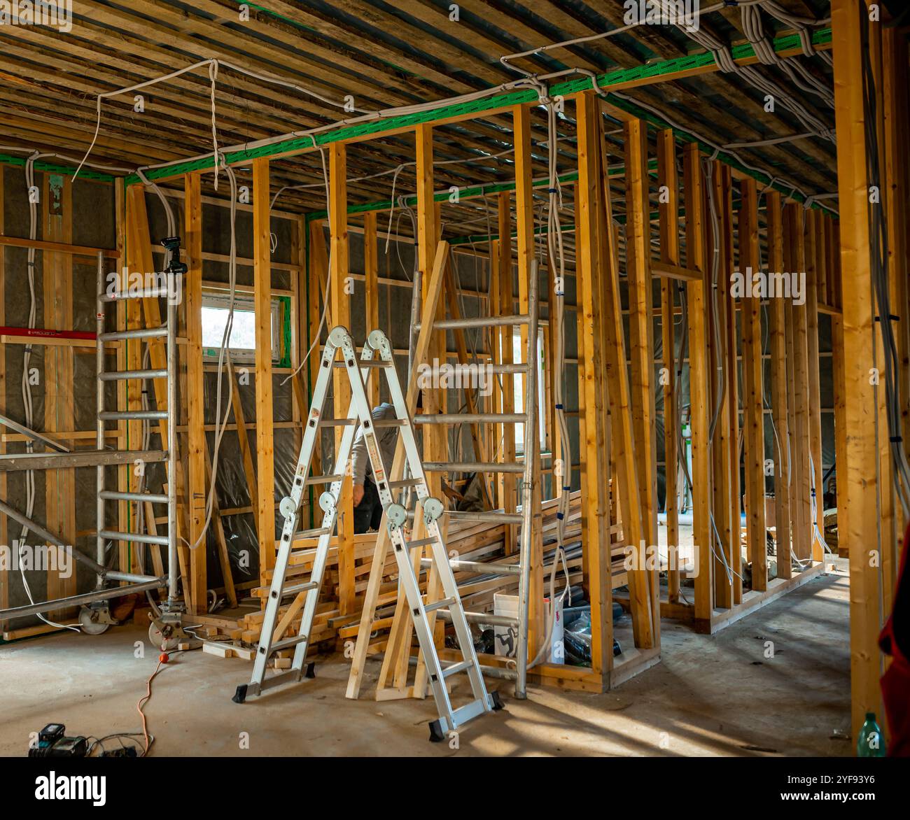 Under-construction home interior with wooden framing, electrical wiring ...