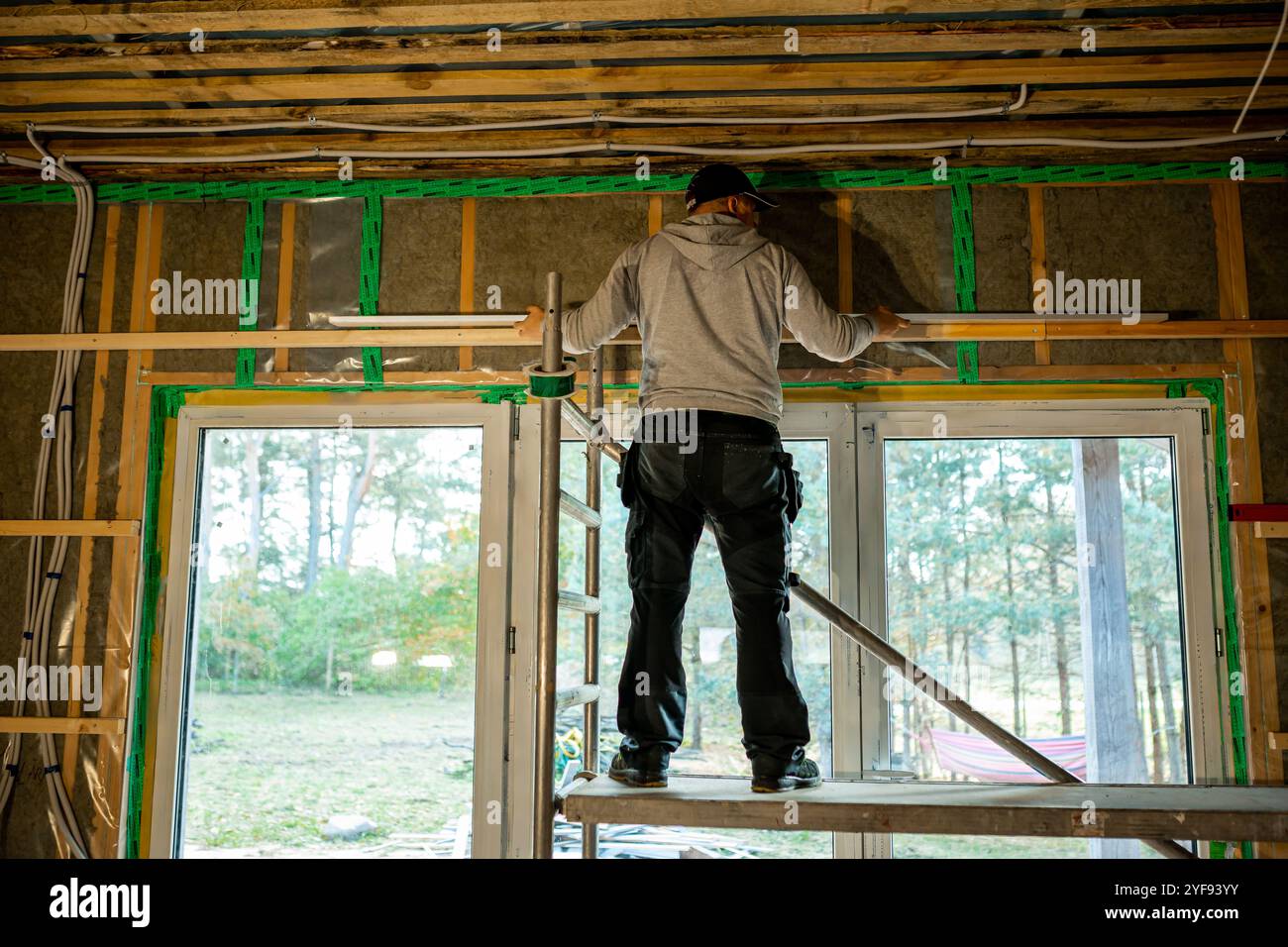 Skilled worker installing windows in a new construction with exposed ...