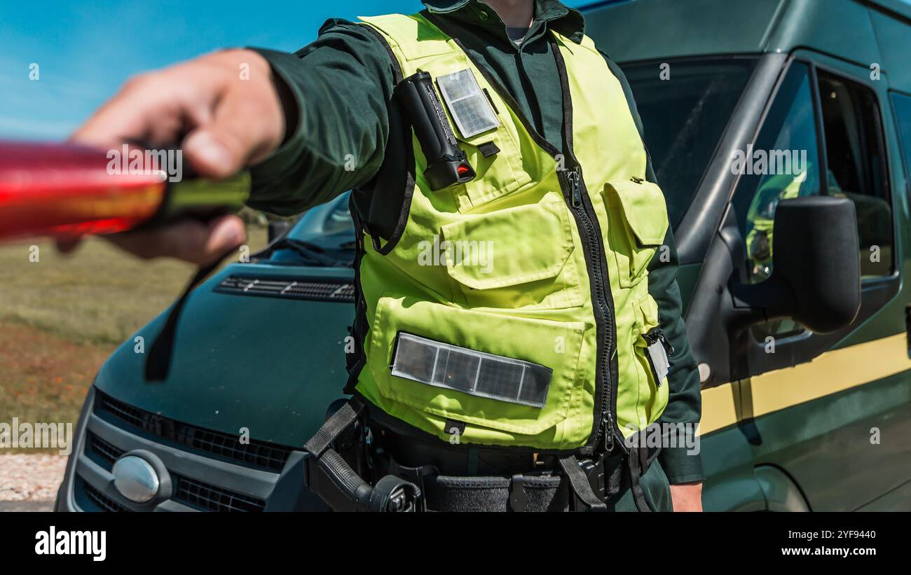 Traffic officer in high-visibility vest holding a baton for road ...