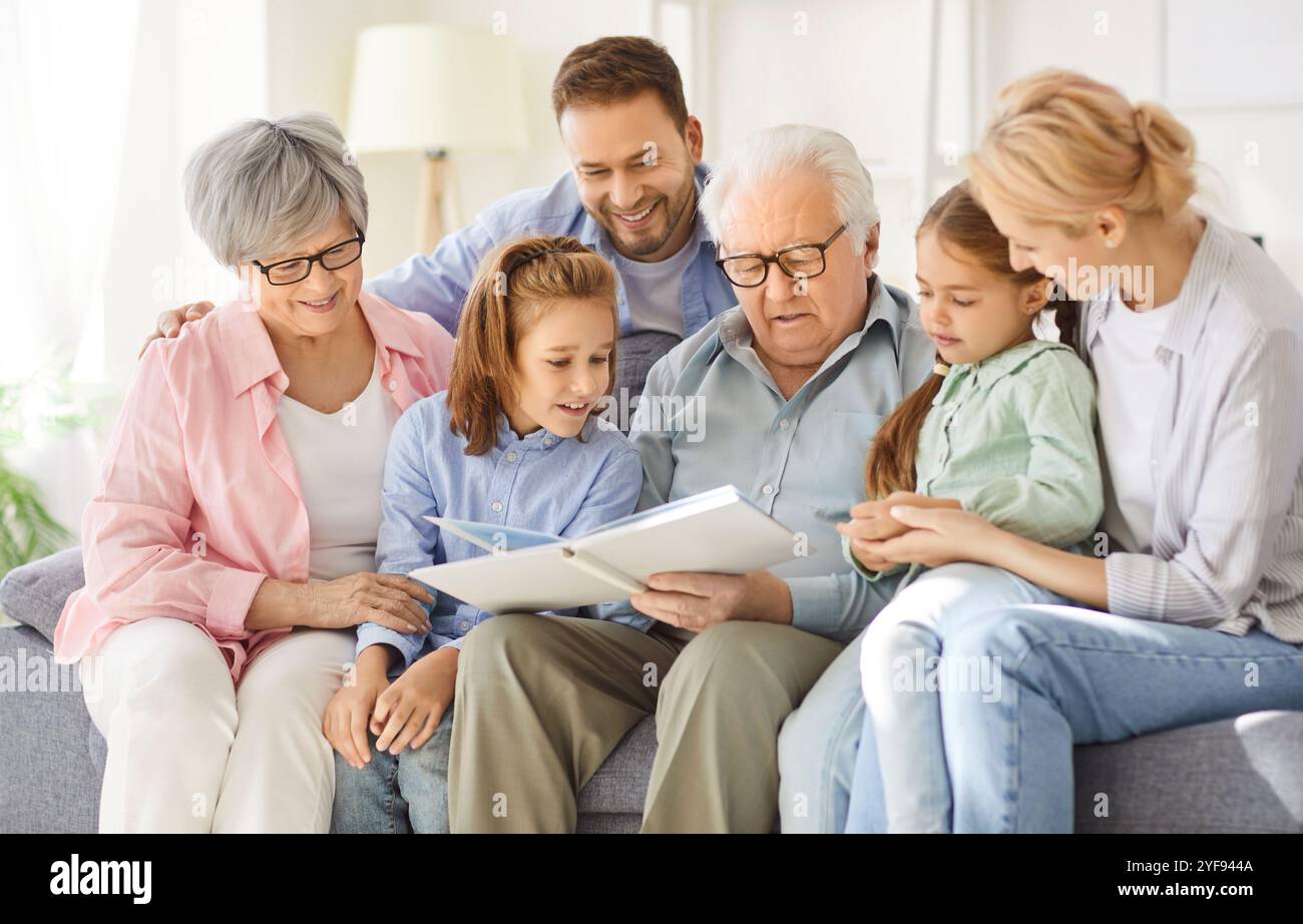 Three generations family portrait enjoying watching childhood picture ...