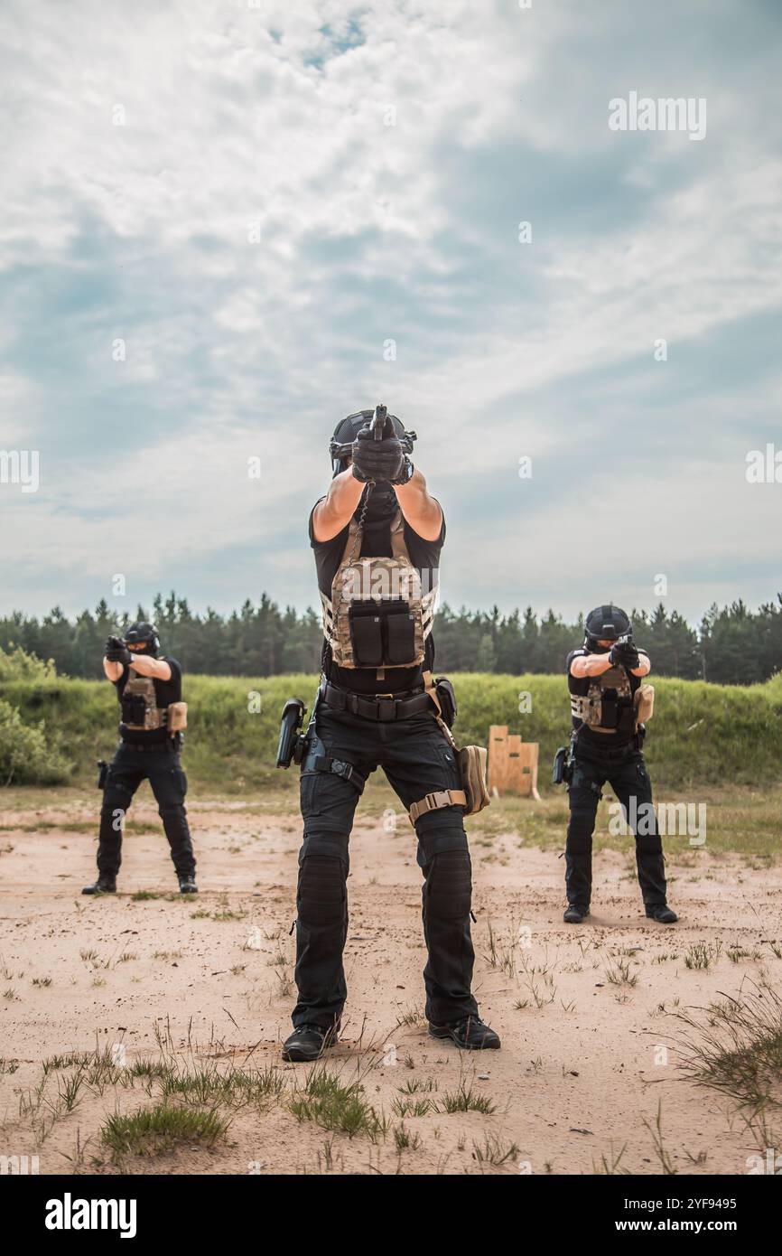 Special forces operatives in tactical gear practicing firearms training ...