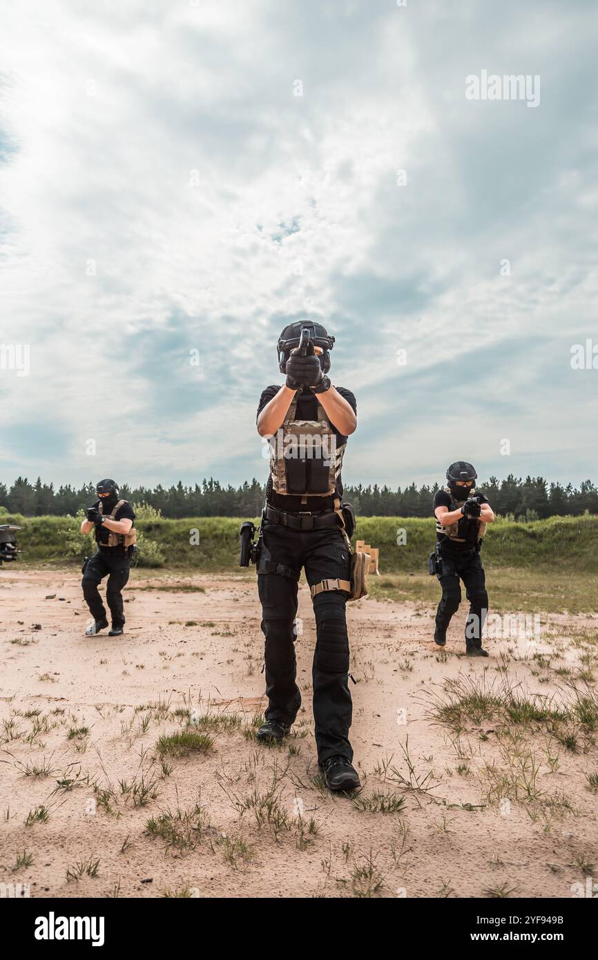 Special forces operatives in tactical gear practicing firearms training ...