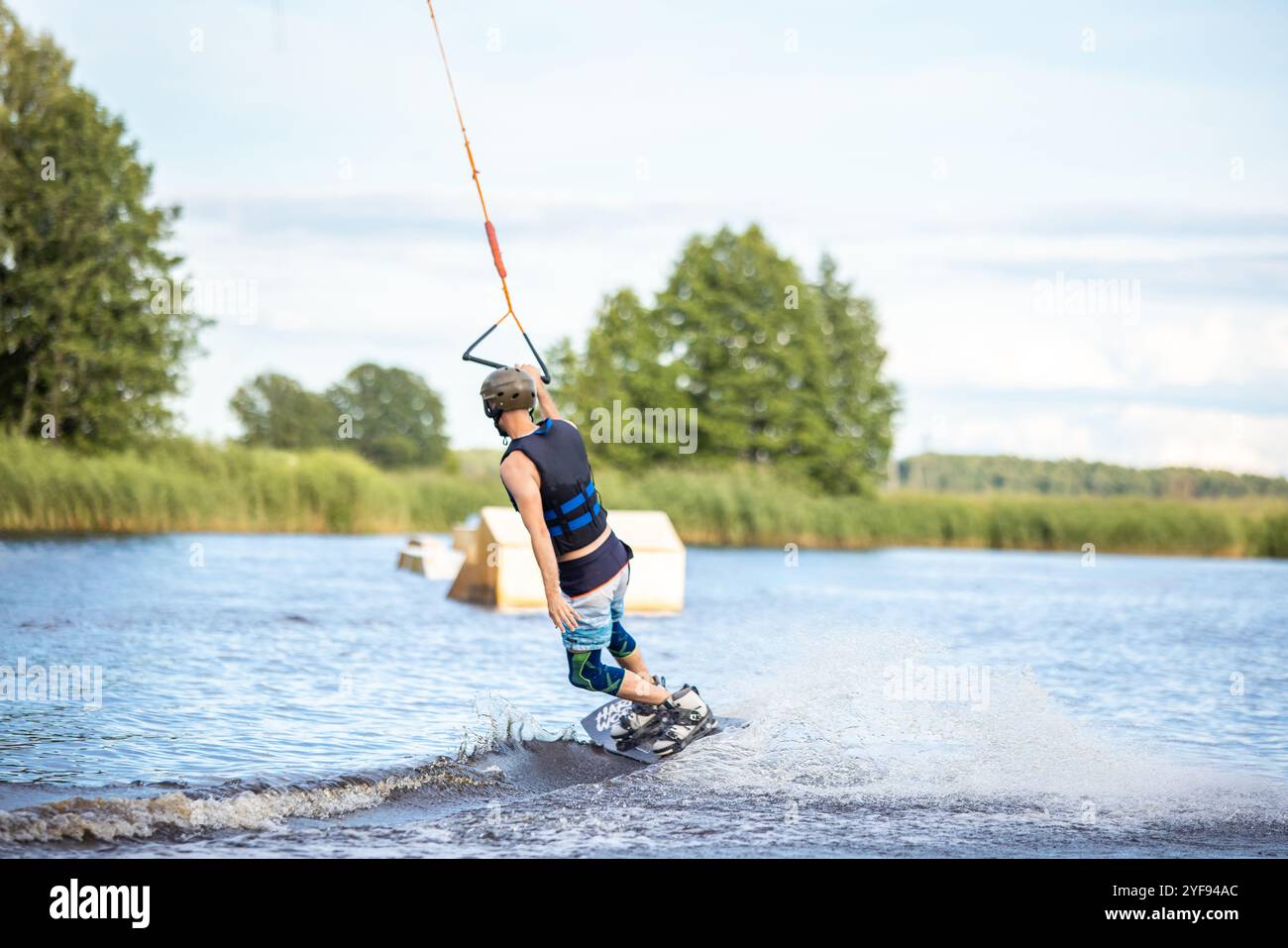Wakeboarding and water sports activity. Man wakeboarding on a lake. Man ...
