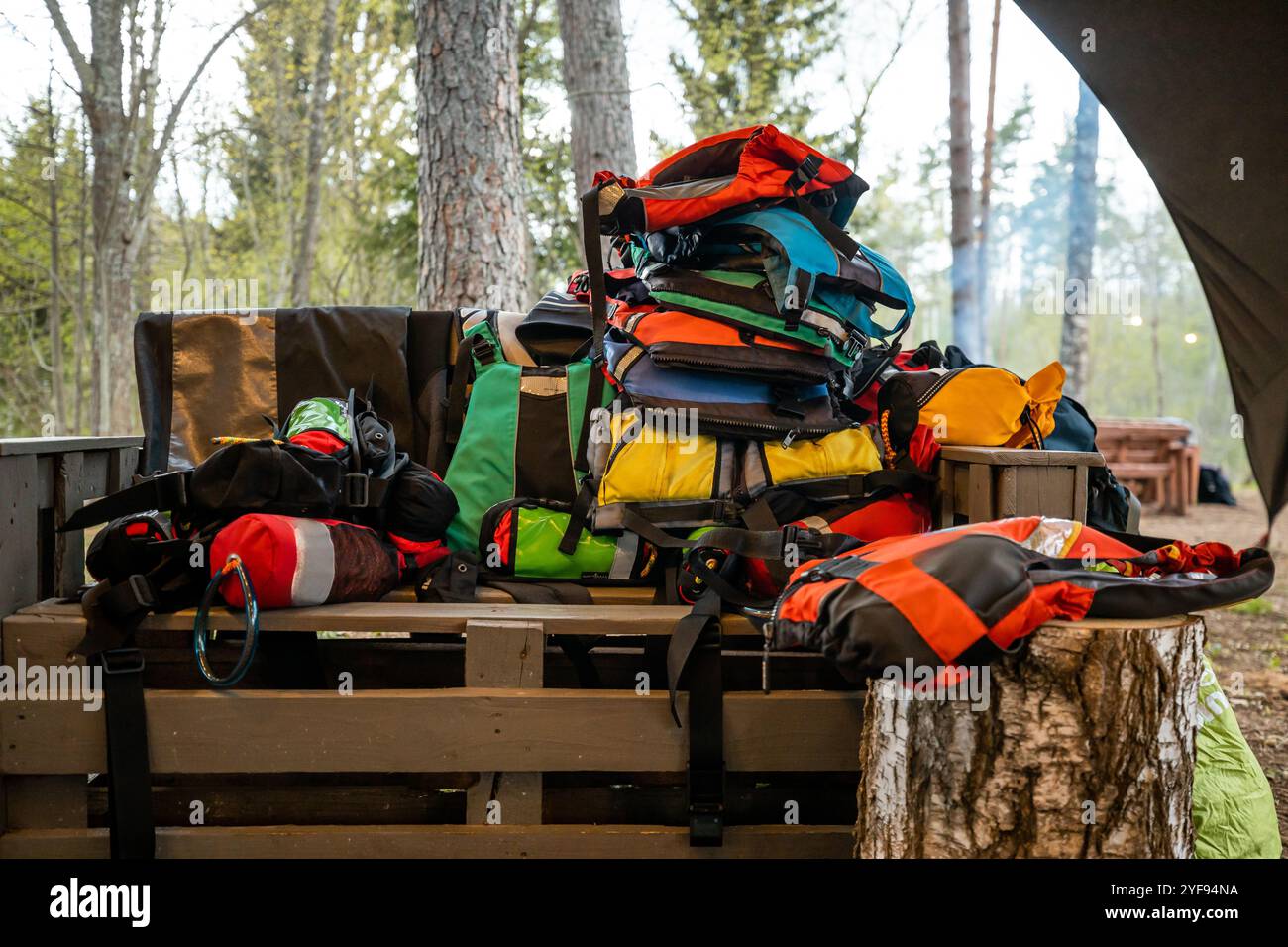 pile of colorful backpacks and camping gear neatly stacked, preparing ...
