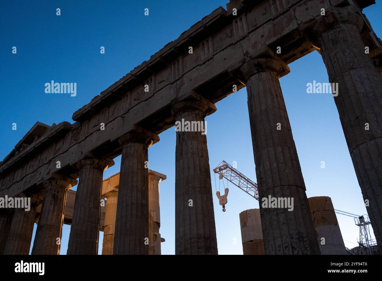 The Parthenon temple under renovation construction with crane and scaffolding on the Acropolis ...