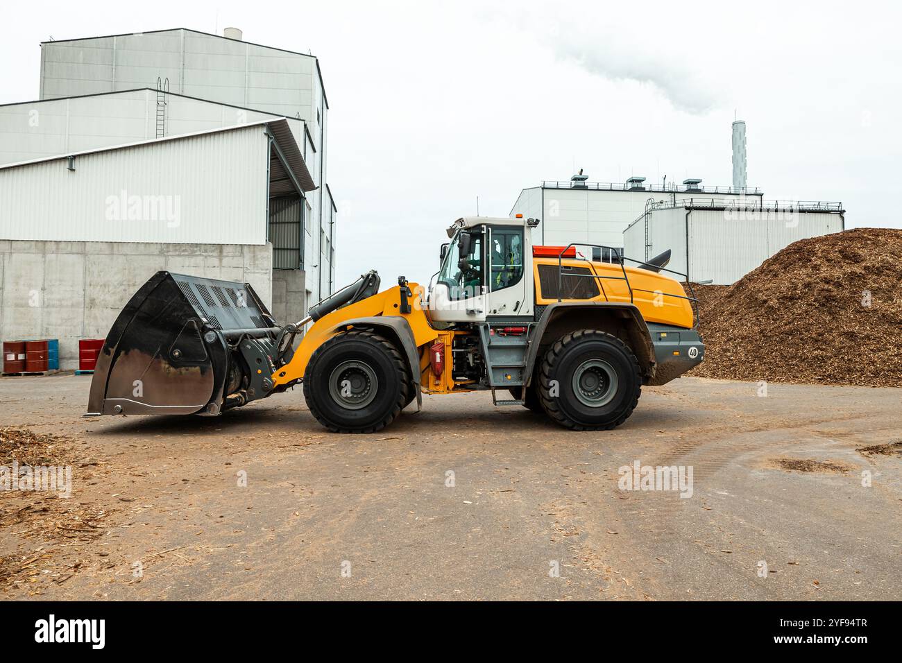 industrial wheel loader with raised bucket at a biomass power plant ...