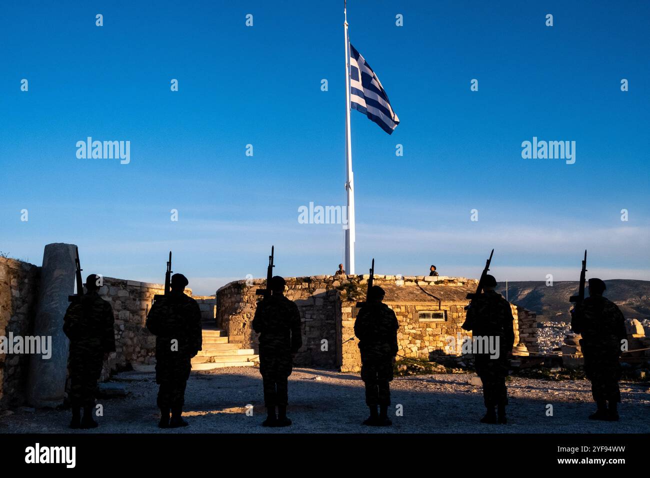 Soldier from the Greek army taking down the Greek flag at sunset close ...