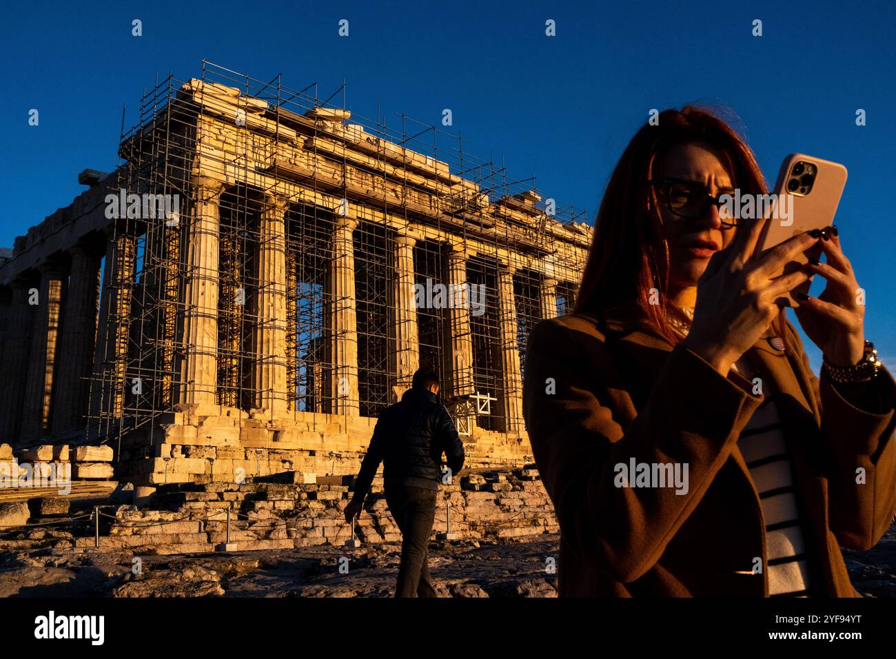 Tourist in front of the Parthenon temple under renovation construction with crane and ...