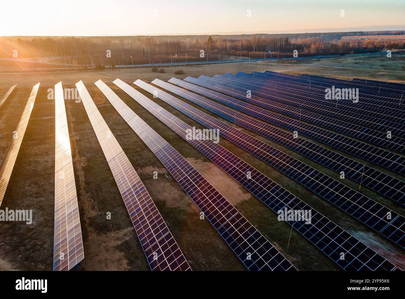 Aerial view of industrial sized solar panel farm during sunset ...