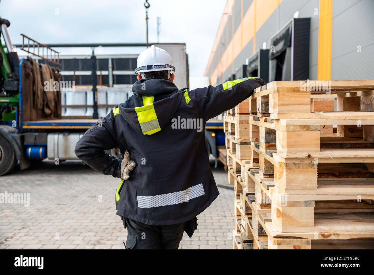 Worker in Safety Gear Directing Forklift Operations at an Industrial ...
