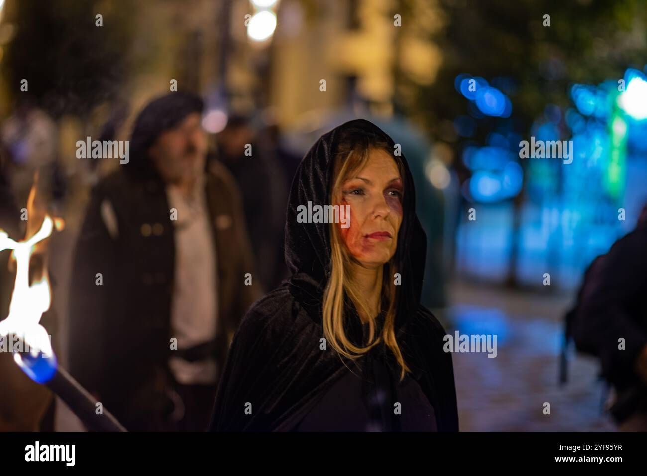 Actor characterized with pale makeup and costumes with flames in night ...