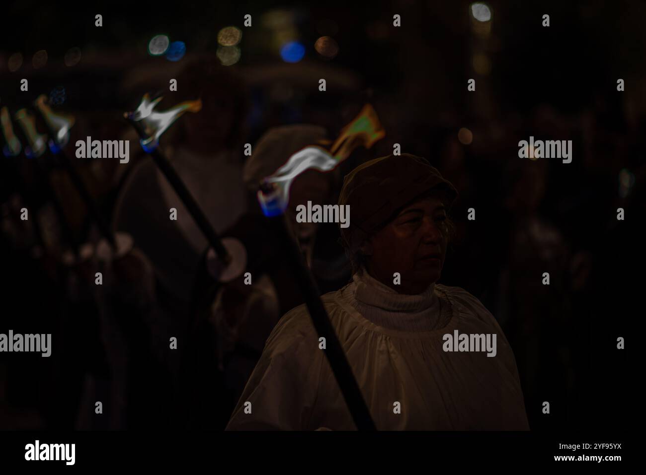 Actor characterized with pale makeup and costumes with flames in night ...