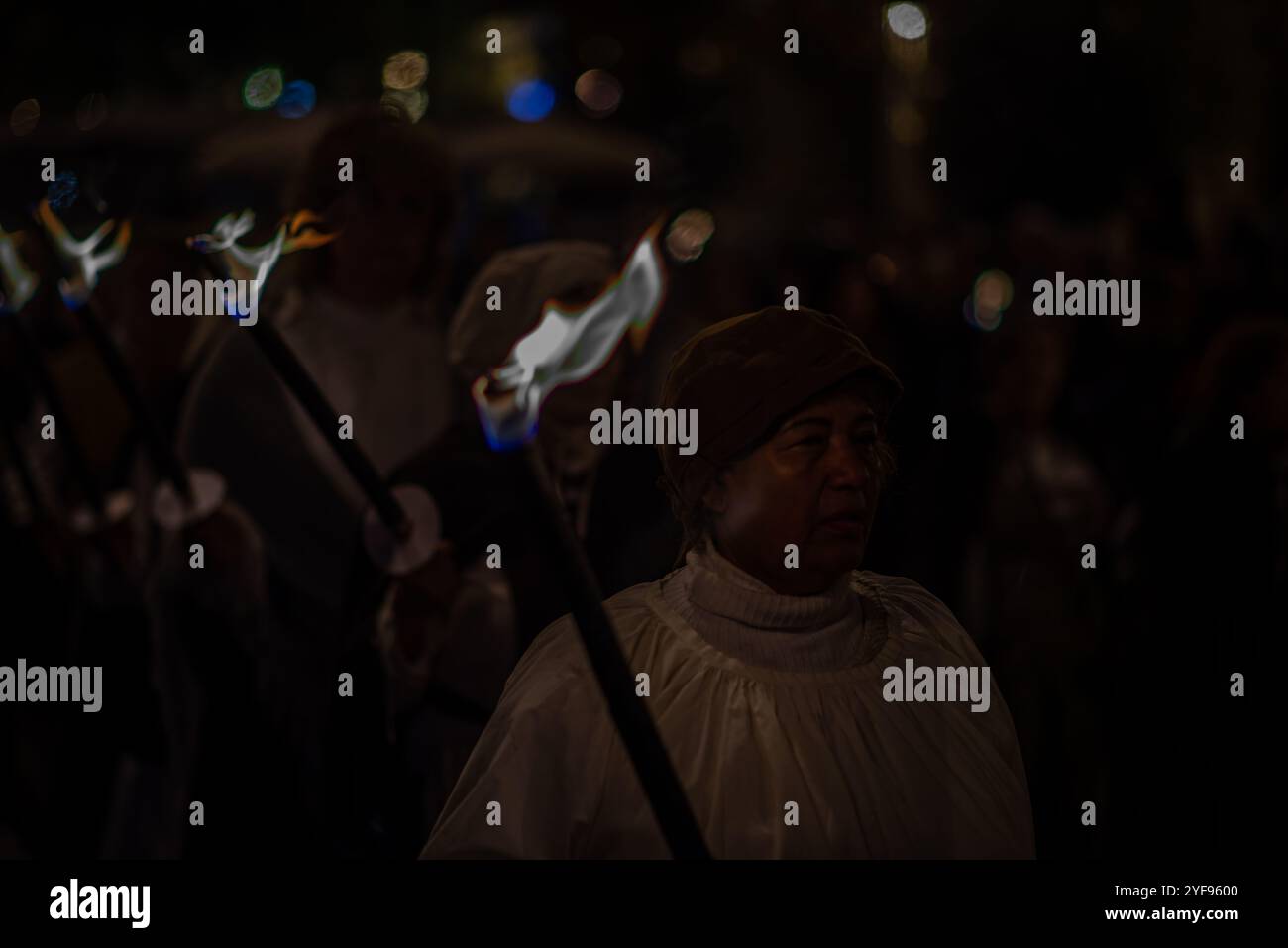 Actor characterized with pale makeup and costumes with flames in night ...