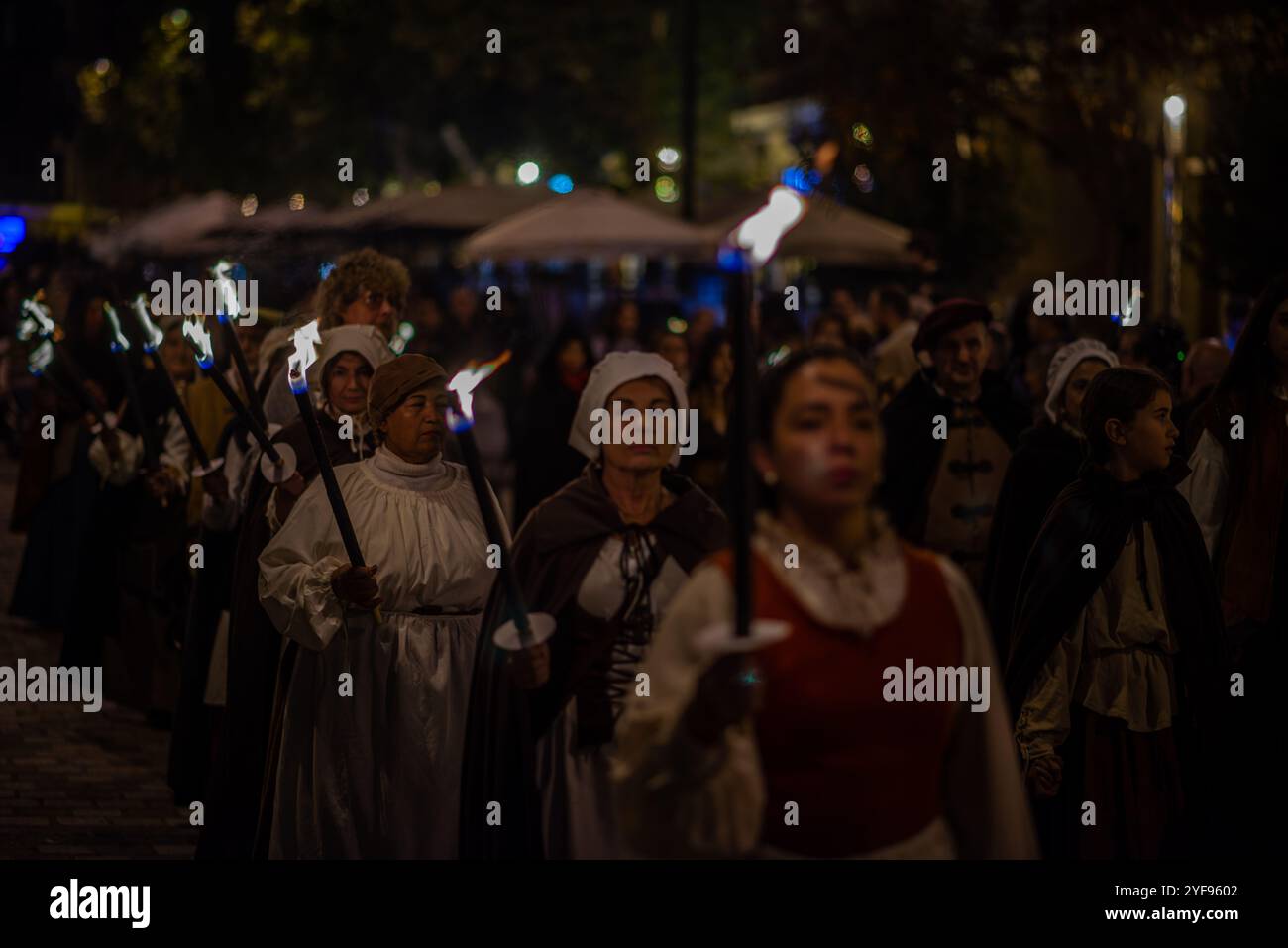 Actor characterized with pale makeup and costumes with flames in night ...