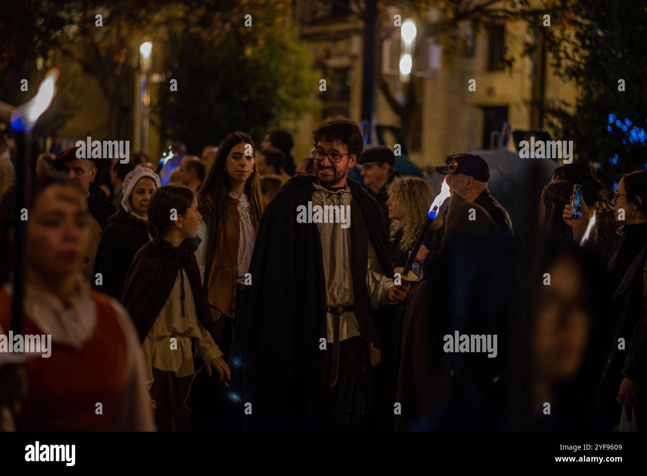 Actor characterized with pale makeup and costumes with flames in night ...