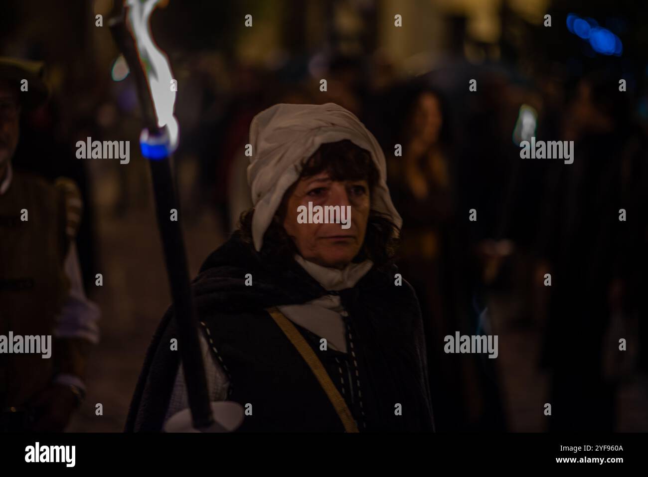 Actor characterized with pale makeup and costumes with flames in night ...