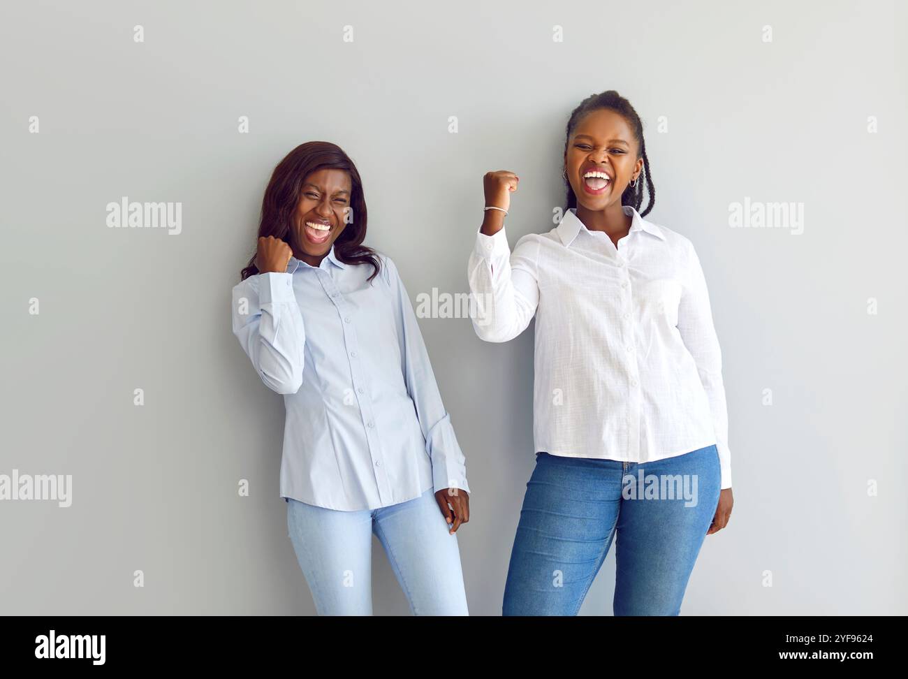 Positive African American Women Celebrating Success on Grey Background ...