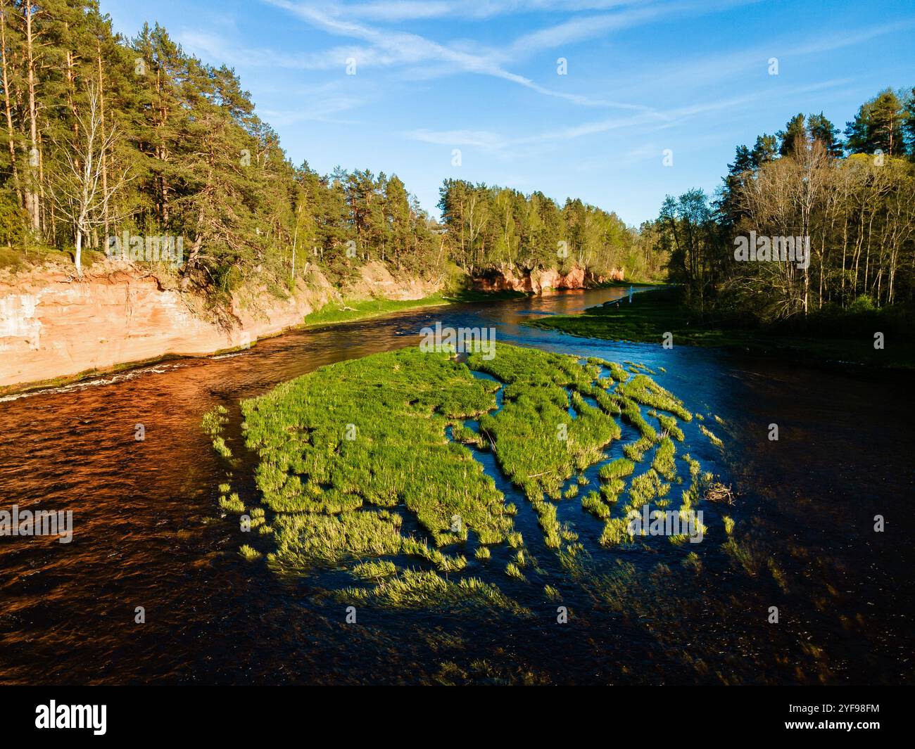 aerial view of the striking red cliffs and lush forests along a curving ...