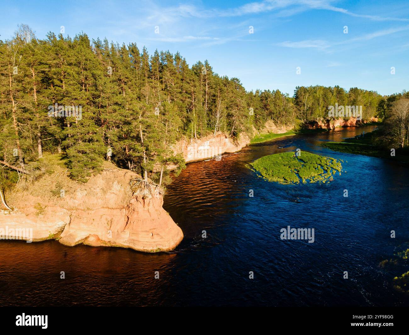 aerial view of the striking red cliffs and lush forests along a curving ...