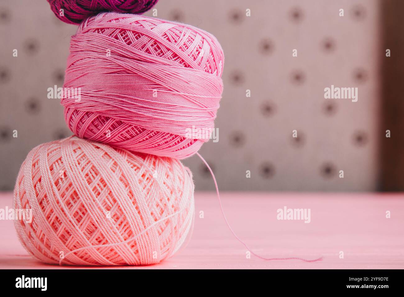 Beautifully arranged yarn balls in pink shades and lace ribbon, ideal ...