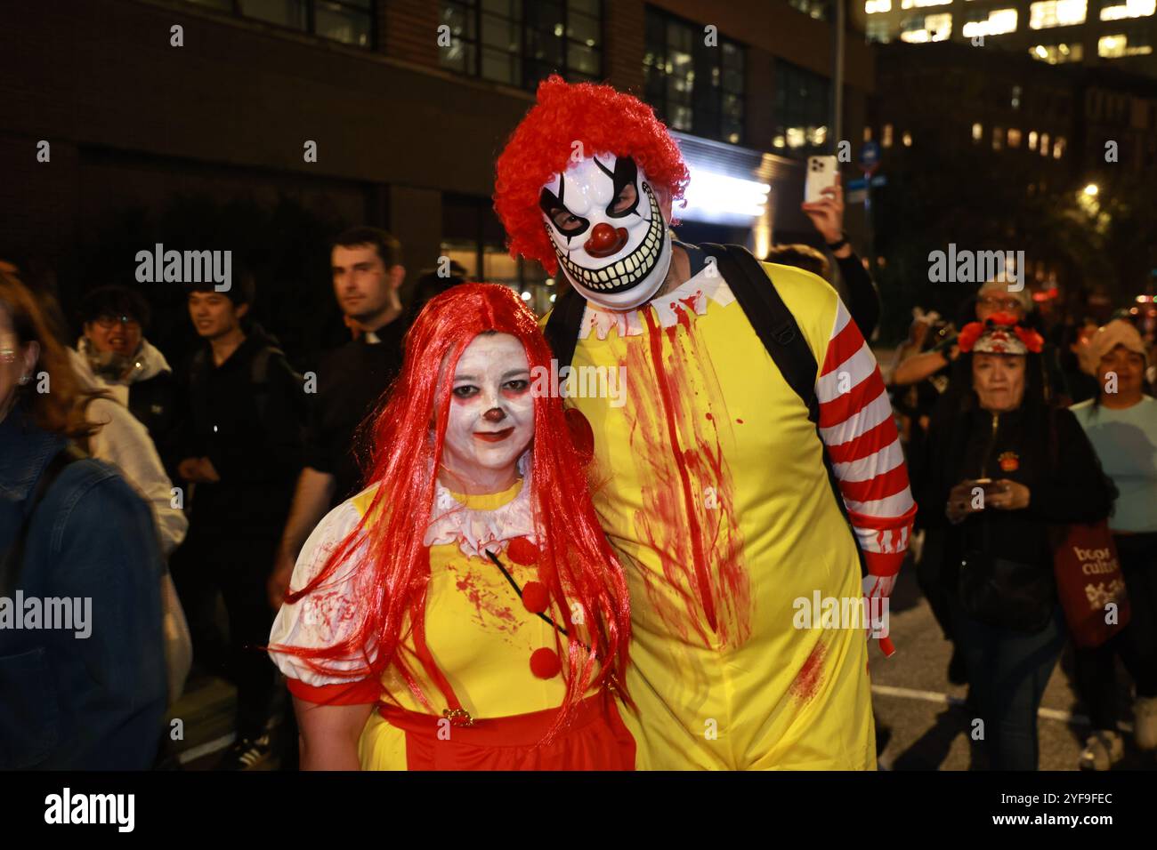 A couple dressed as killer clowns pose for a photo during the New York ...