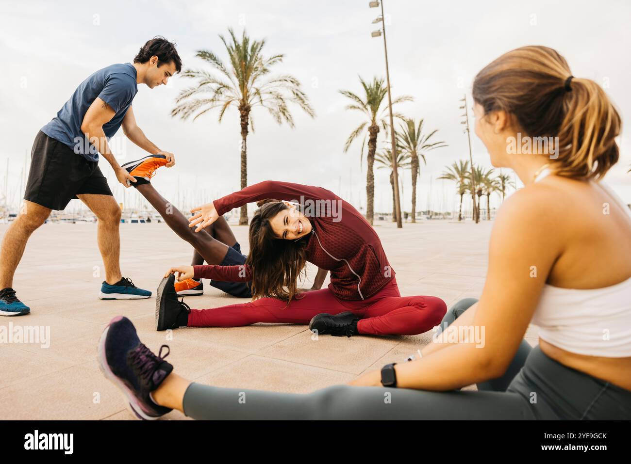 A diverse group of young adults performing stretching exercises ...