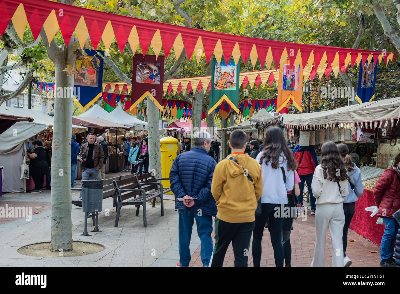 Street market with colorful medieval fair decorations in Barcelona ...