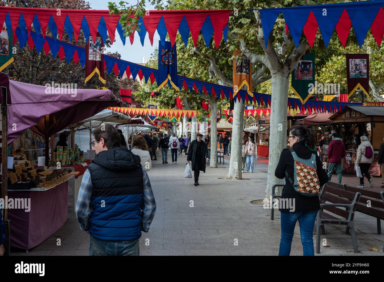 Street market with colorful medieval fair decorations in Barcelona ...