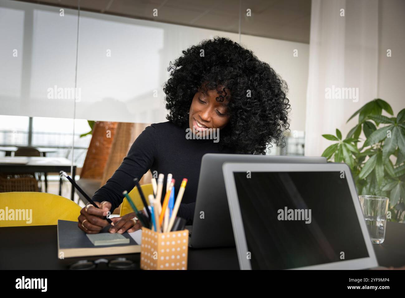 Female business professional writing notes on notepad in office Stock ...