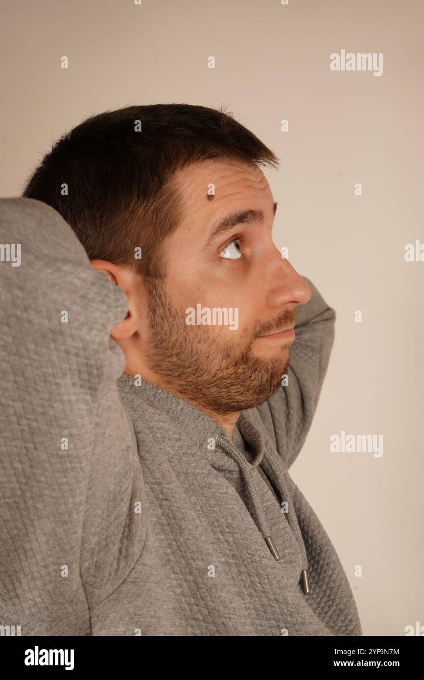 Face with satisfaction. Crossed hands over head. Young guy standing in ...