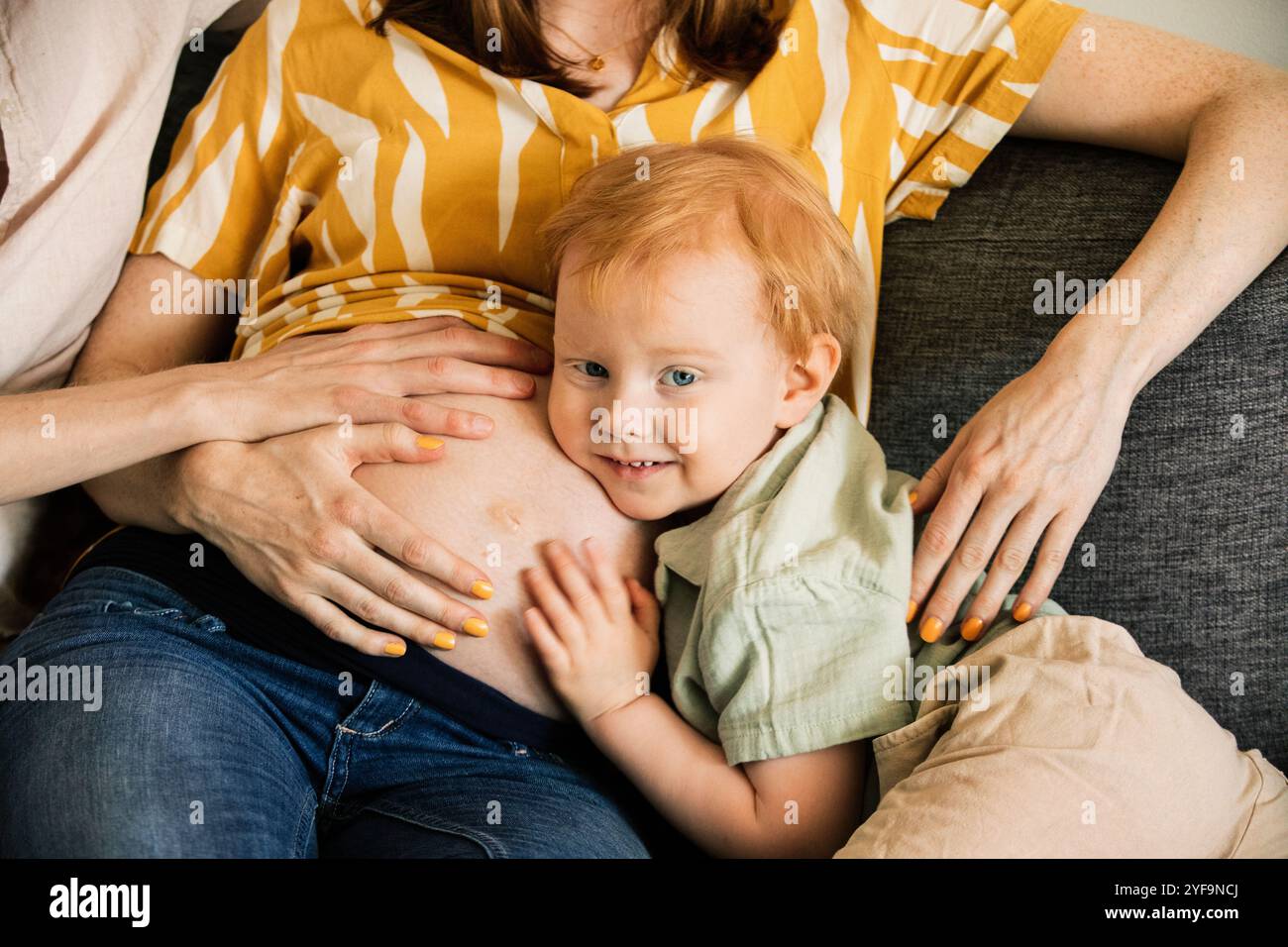 Playful father and son touching abdomen of pregnant woman Stock Photo ...