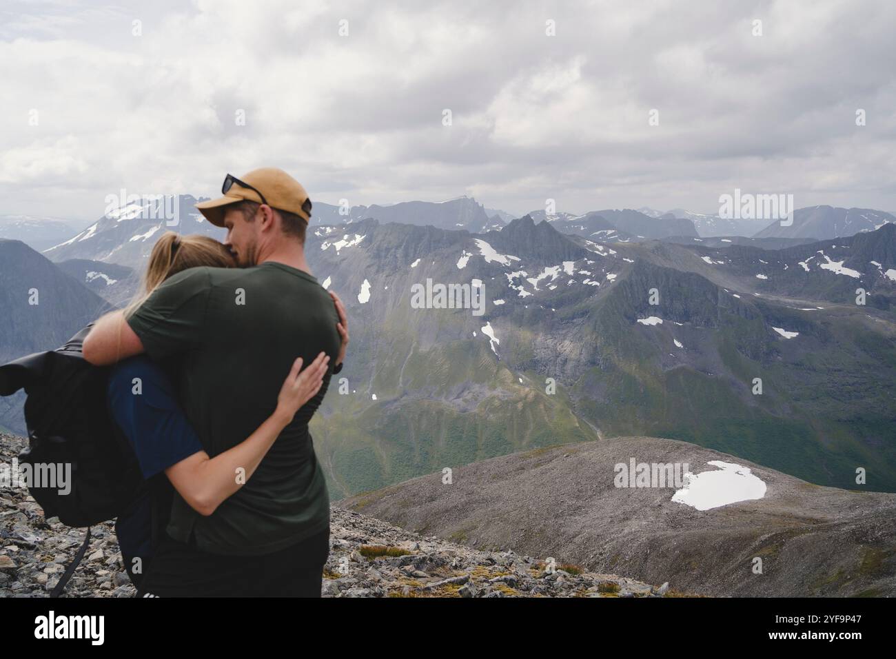 Loving boyfriend kissing girlfriend while hugging on mountain Stock ...