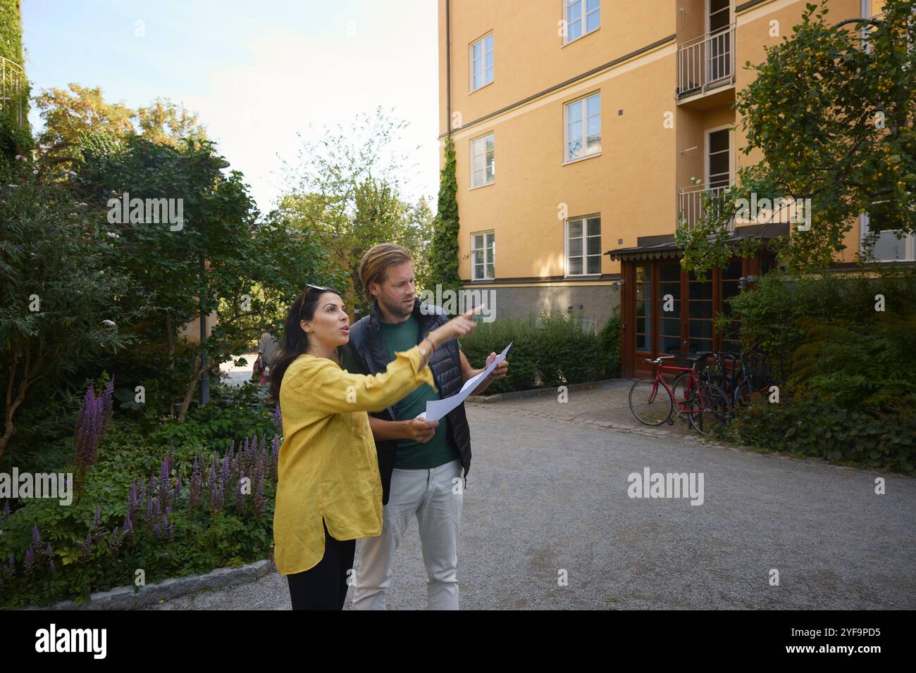 Female architect pointing while standing with male colleague examining ...