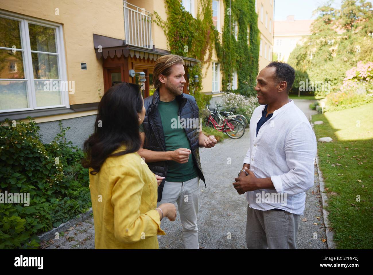 Male and female neighbors talking with each other while standing on ...