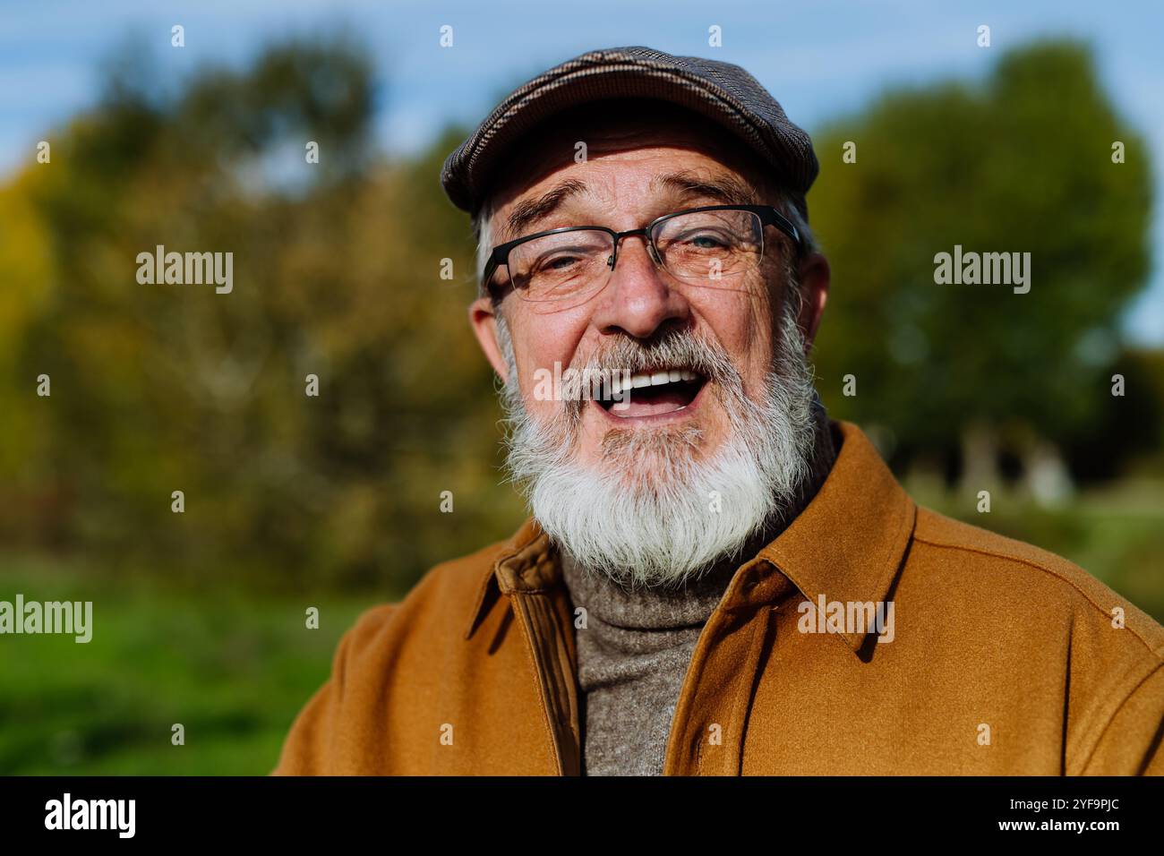 Portrait of friendly older man with a gray beard. Senior standing ...
