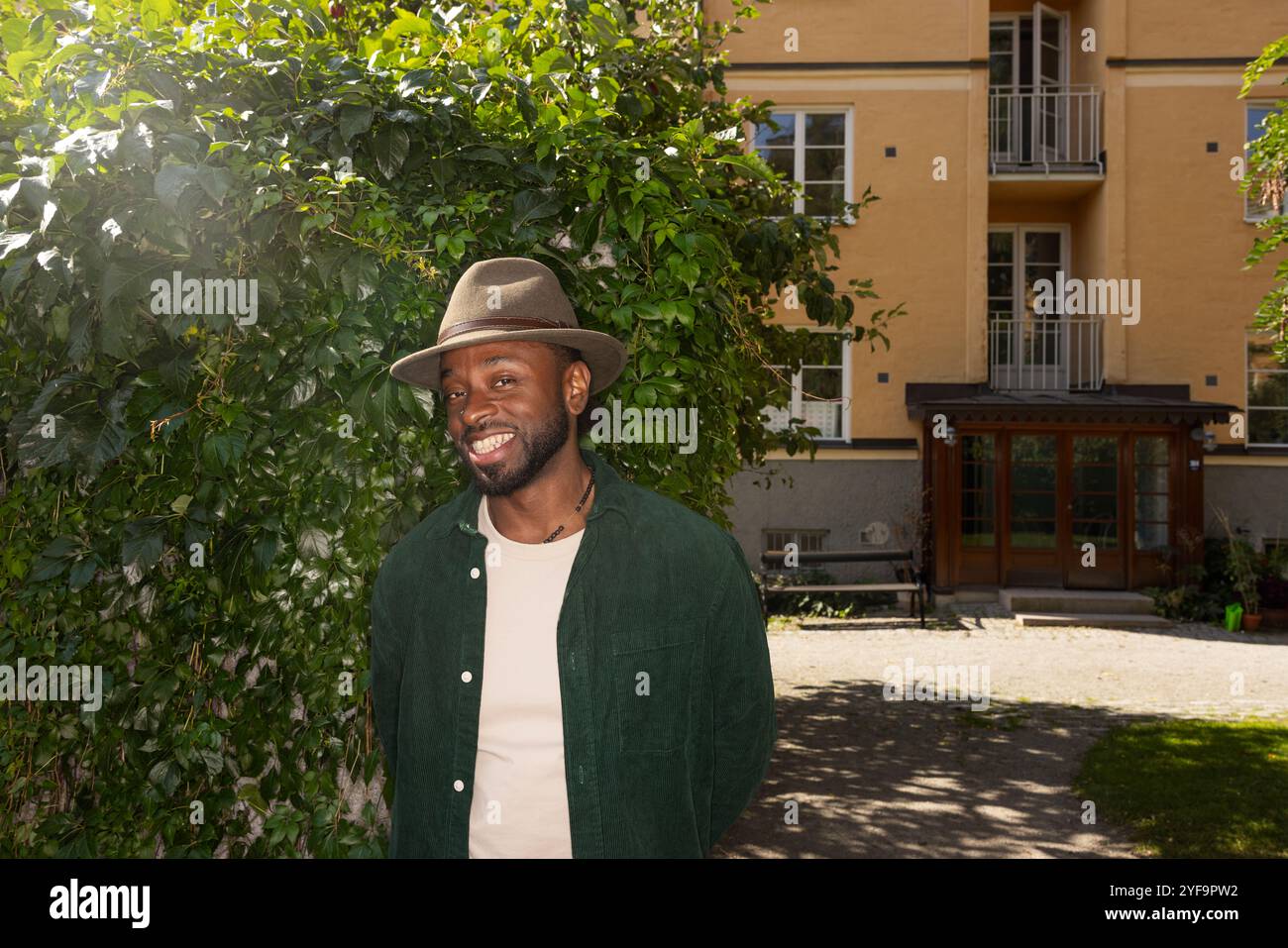 Portrait of smiling young man standing outside building Stock Photo - Alamy
