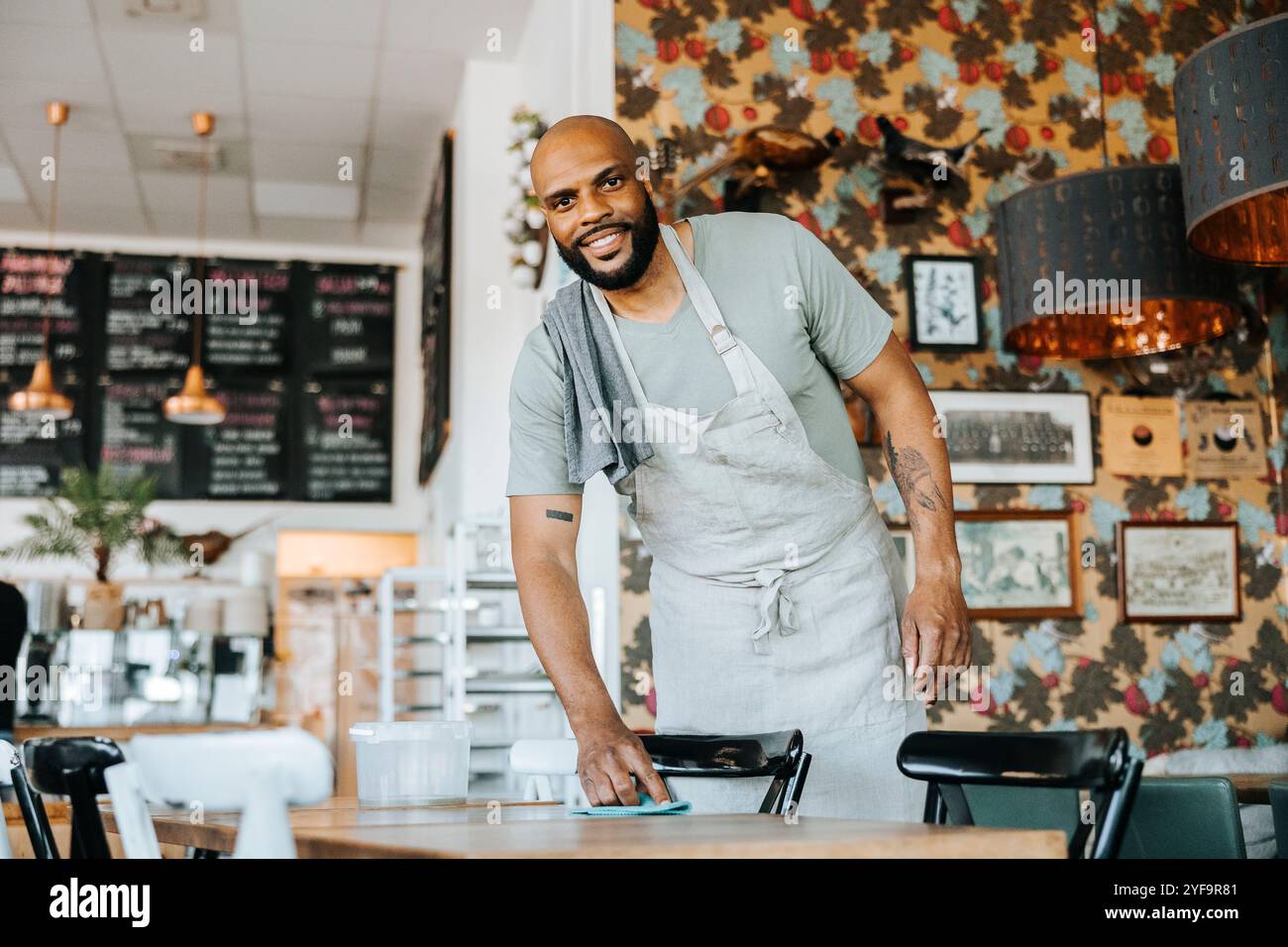 Portrait of waiter cleaning table in coffee shop Stock Photo - Alamy