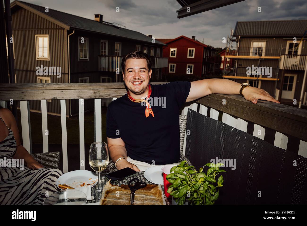 Portrait of handsome young man sitting in balcony at dusk Stock Photo ...