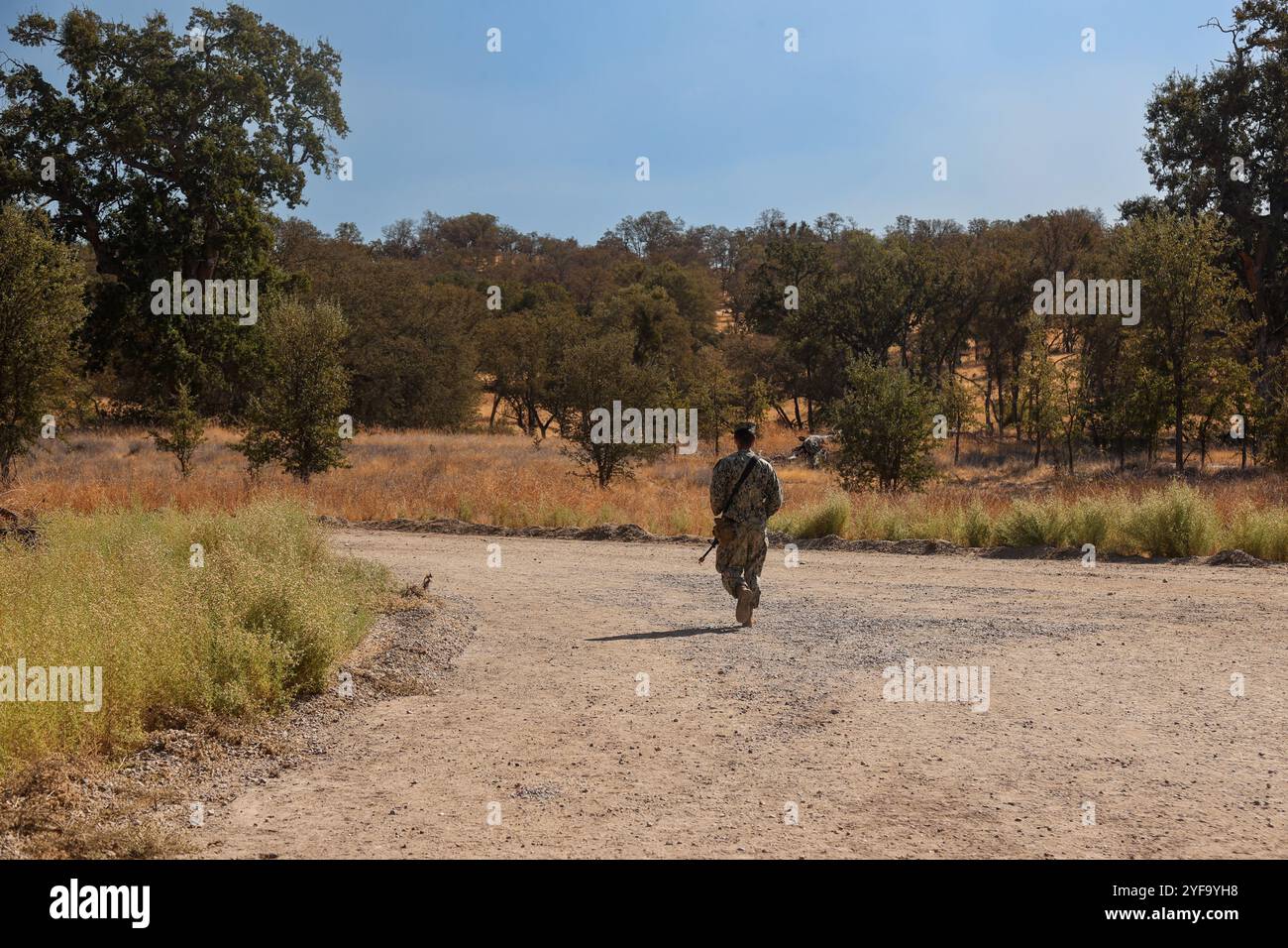 A Sailor assigned to Naval Mobile Construction Battalion (NMCB) 4 walks ...
