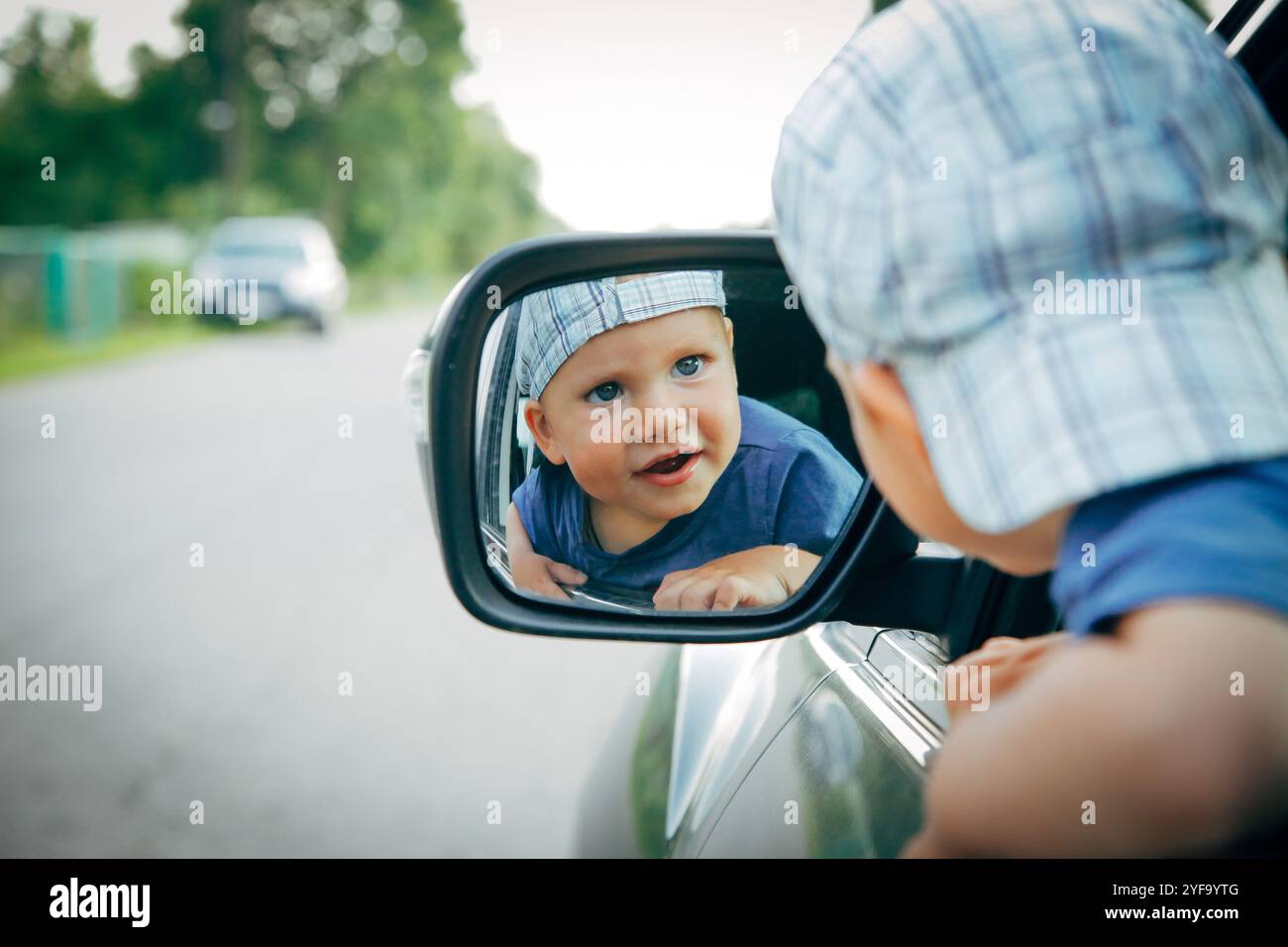 The kid stares intently into the car mirror Stock Photo - Alamy