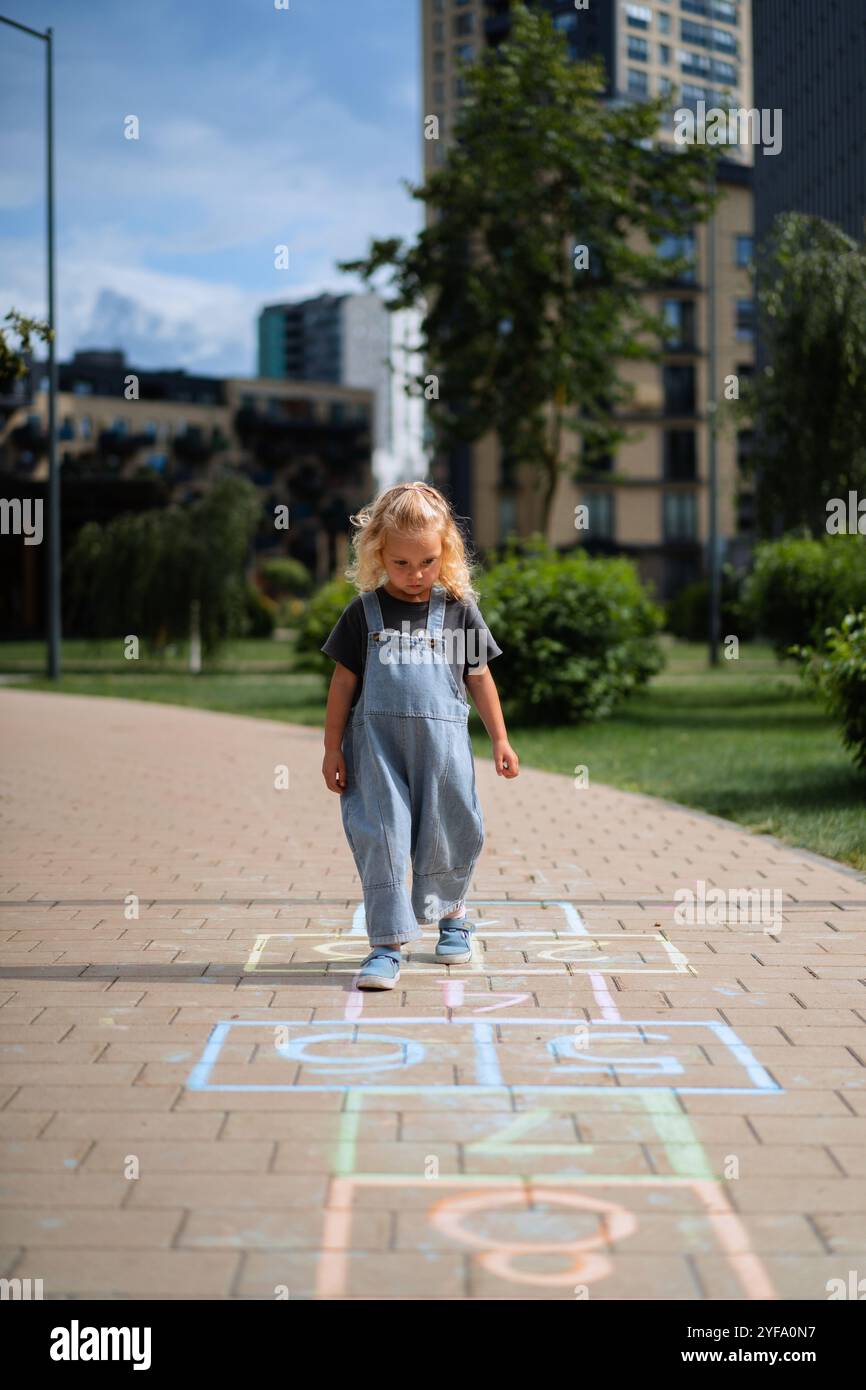 Girls playing hopscotch in the yard in the summer Stock Photo - Alamy