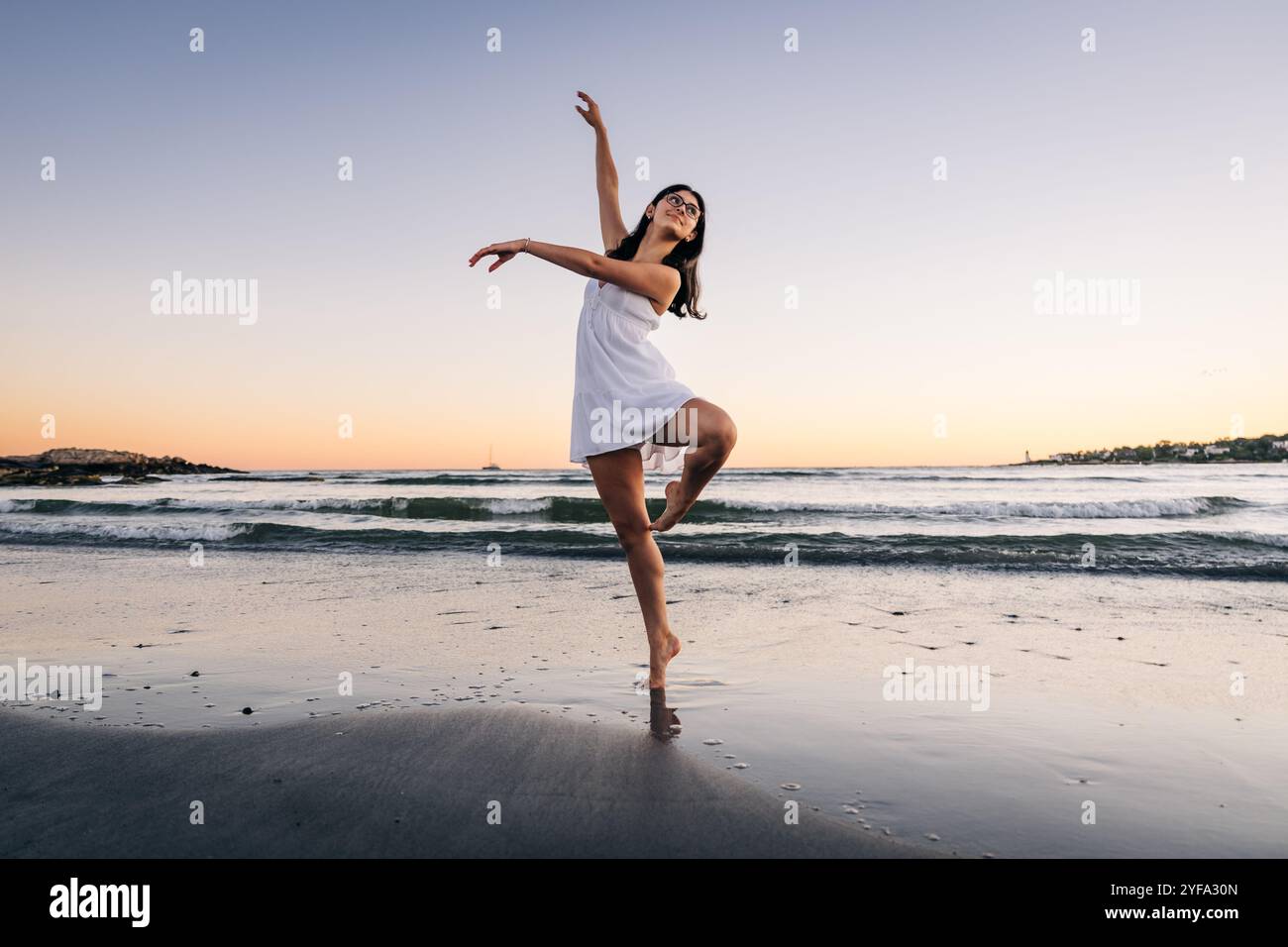 Woman dancing barefoot on the beach at sunset in white dress Stock Photo - Alamy