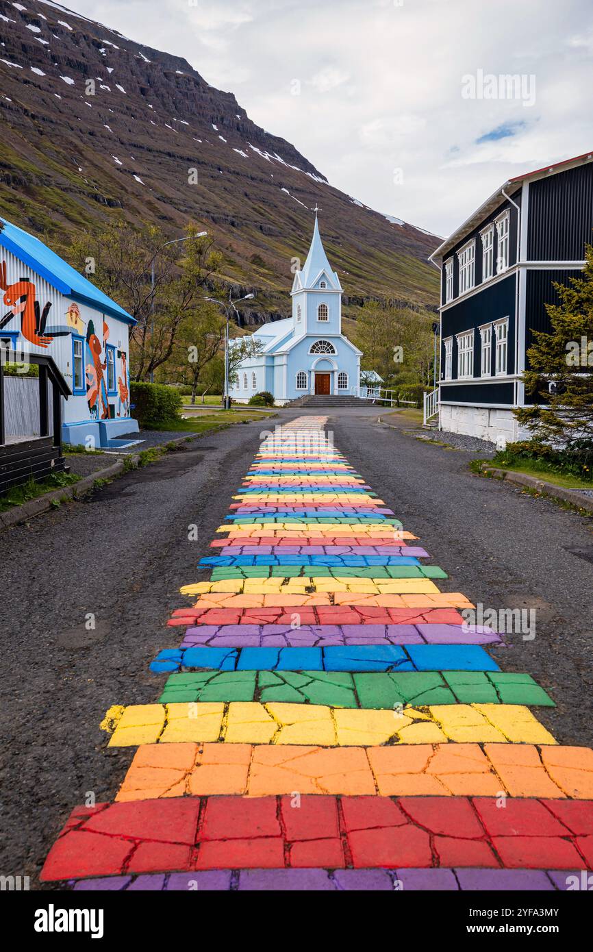The famous rainbow road in Seydisfjordur with icelandic buildings ...